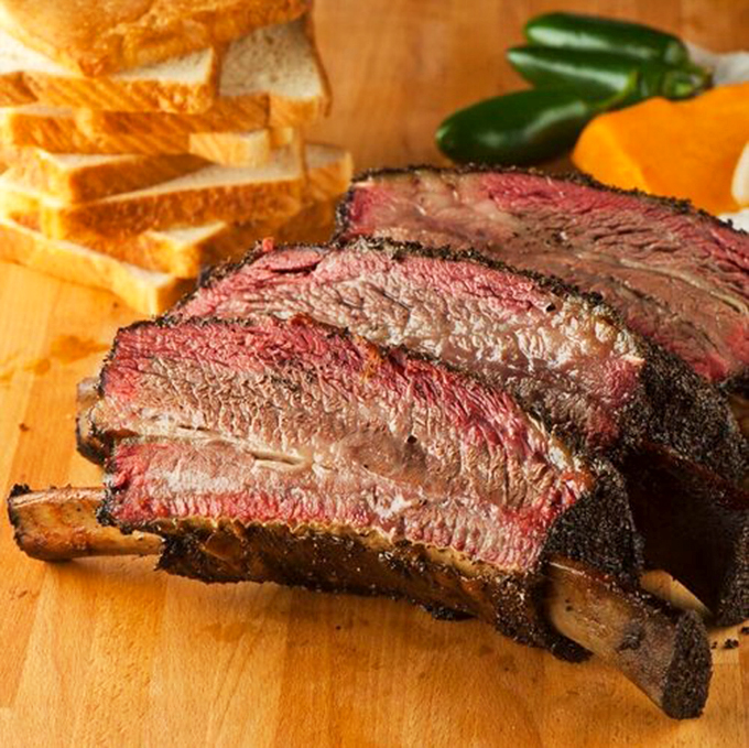 Beef ribs so massive they look like they came from a prehistoric cow. The pepper-crusted bark protects meat so tender it practically surrenders to your fork.