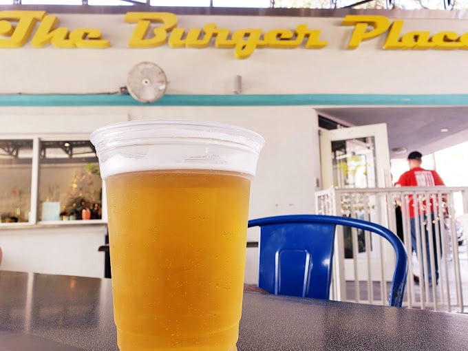 Nothing complements a perfect burger like a cold beer, especially when enjoyed under that iconic yellow sign on a sunny Florida afternoon.