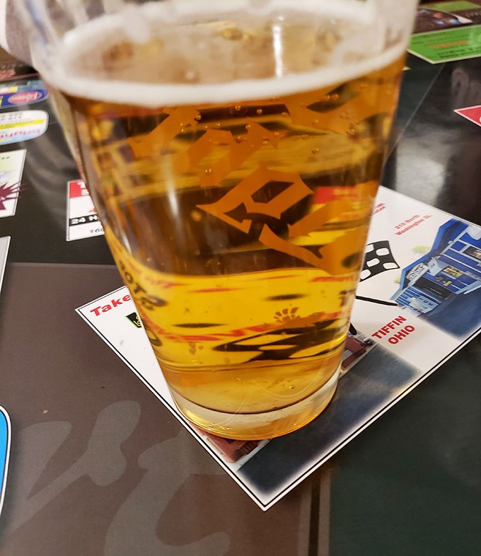 A cold beer on a table of local advertisements&mdash;the perfect companion to pizza and a window into the community that keeps this place thriving.