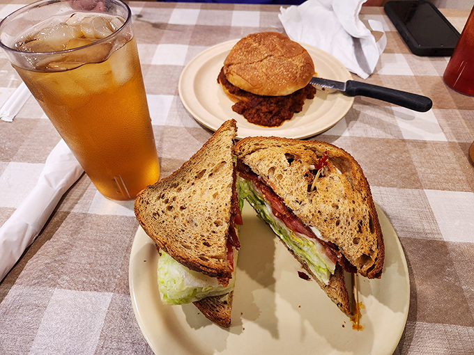 A sandwich cut on the diagonal&mdash;as civilization demands&mdash;revealing layers of BLT perfection. Sweet tea standing by for the necessary refreshment.