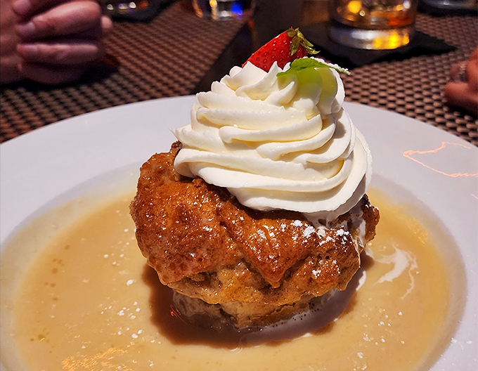 Bread pudding elevated to art form, swimming in sauce and topped with enough whipped cream to make your cardiologist wince approvingly.