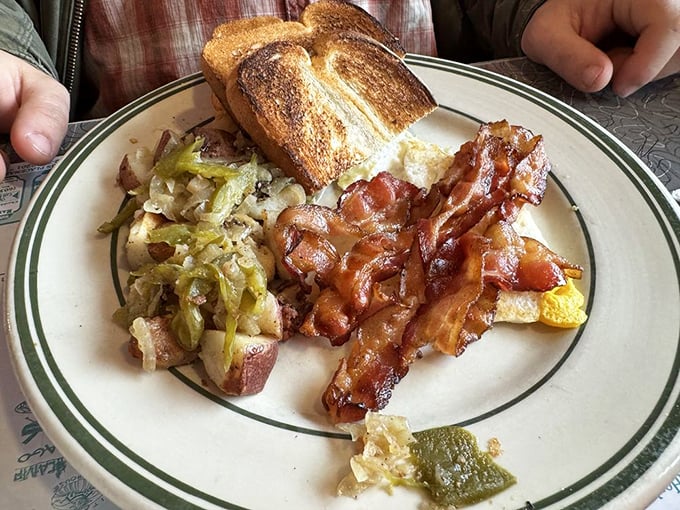 The breakfast trinity: perfectly crisped bacon, golden toast, and eggs that hit that sweet spot between runny and set. Simple perfection on a plate.