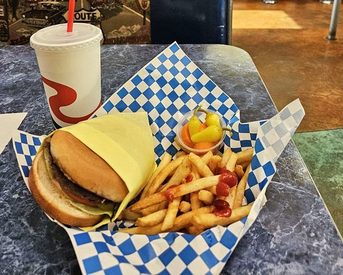 This classic burger and fries arrives on blue checkered paper—a simple combination that has survived food trends because perfection needs no improvement.