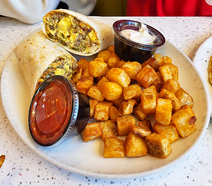 A breakfast burrito flanked by home fries so perfectly golden they deserve their own Instagram account.