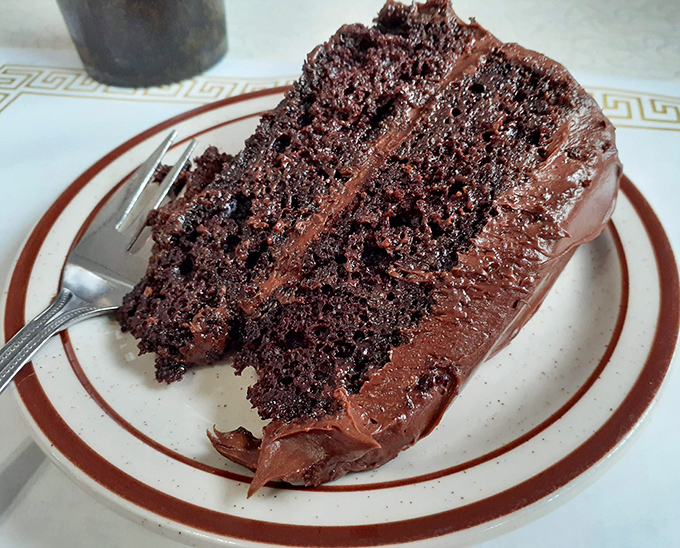 Chocolate cake so rich it should have its own tax bracket. Two layers of cocoa decadence that make a compelling case for dessert being an acceptable breakfast choice.