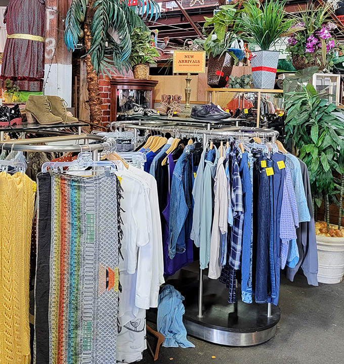 The clothing section blooms with color amid lush plants, proving that even in a warehouse of castoffs, nature and fashion find harmony.