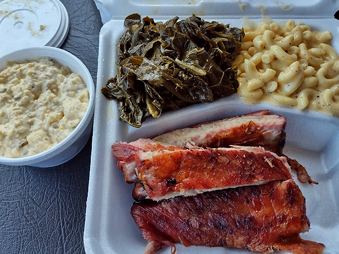 A tray of smoky goodness featuring ribs, collard greens, and mac and cheese&mdash;the barbecue trifecta that makes resistance futile.