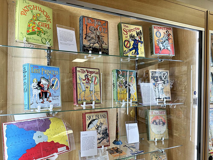 First editions and rare Oz books line these glass shelves, showcasing Baum's expansive universe beyond just the famous first tale.