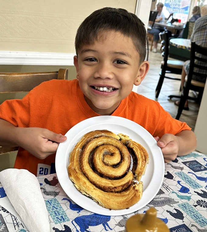 The look of pure joy that comes from knowing you're about to devour a cinnamon roll bigger than your childhood dreams.