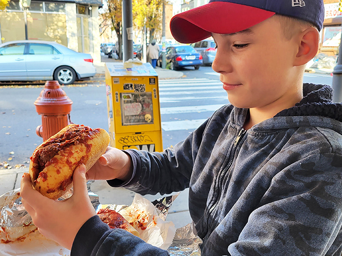The sidewalk becomes a dining room when your sandwich can't wait. Some pleasures demand immediate attention.