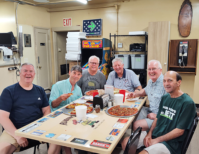 Multi-generational pizza appreciation in action—these gentlemen have probably been debating the merits of square-cut versus triangles since the Nixon administration.