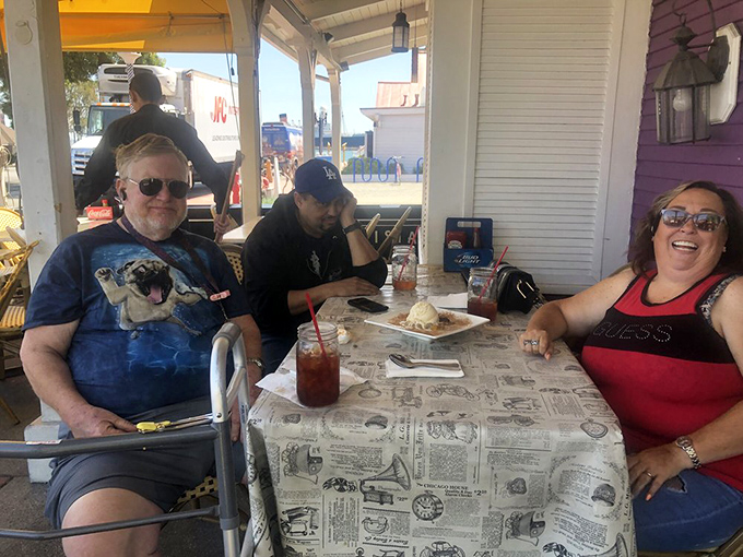 The true measure of a restaurant: happy diners enjoying outdoor seating, newspaper-print tablecloths, and the kind of laughter that only good food inspires.