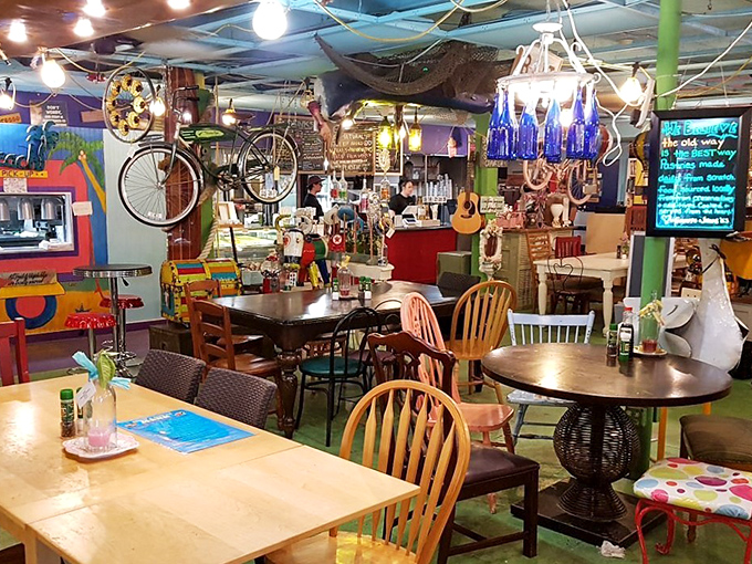 The dining area resembles a colorful jumble sale curated by mermaids, with bicycles hanging from ceilings and mismatched chairs that somehow work perfectly.