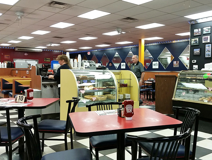 The display case tempts while classic diner tables await. In the background, breakfast dreams are being fulfilled one plate at a time.