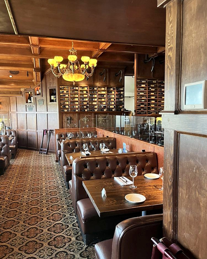 Rich wood paneling, leather booths, and an impressive wine display create an atmosphere that whispers, "Stay awhile. Order dessert. Maybe a second dessert."