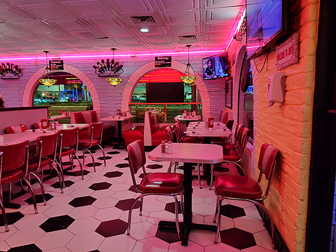 The pink neon glow bathes diners in flattering light, making everyone look like they're in a retro music video about pancakes.
