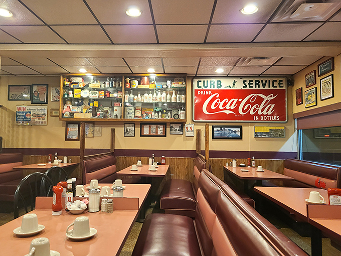 The dining area speaks the universal language of comfort with its vinyl booths, wood-paneled walls, and vintage Coca-Cola signs—a time capsule of American dining.