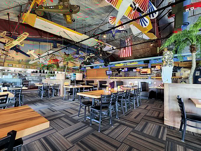 The dining area feels like an aviation museum where food is the main exhibit—model planes suspended in eternal flight while diners enjoy their earthbound delights below.