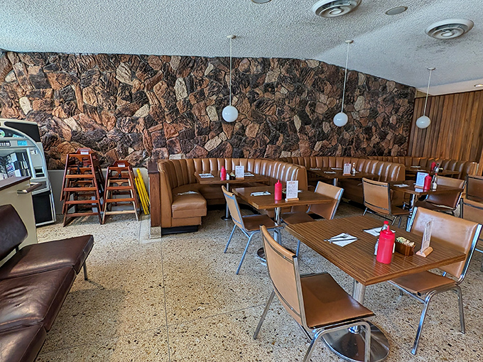 Mid-century stone walls meet caramel-colored booths in a dining room that feels like Don Draper might slide in for a martini and meatloaf special.