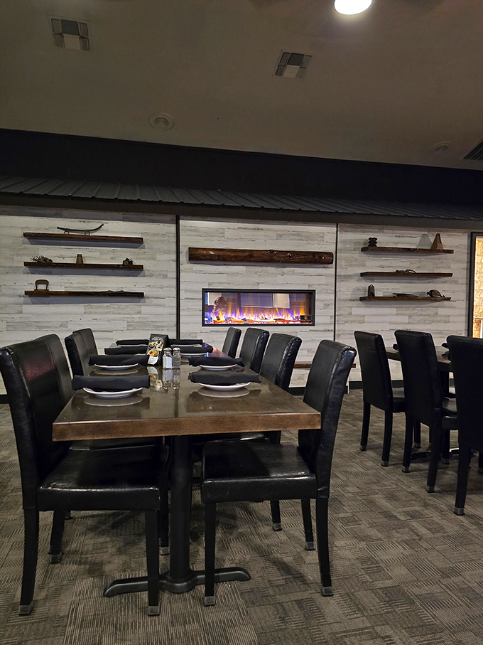 A fireplace flickers behind thoughtfully arranged tables, creating the kind of ambiance that makes you want to linger over one more drink.