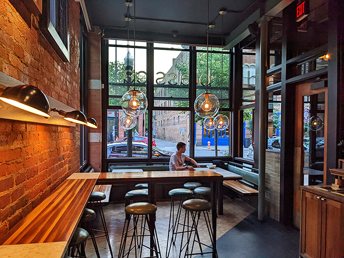 Corner seating bathed in natural light with pendant globes hanging like modern art&mdash;the perfect perch for people-watching between bites of brilliance.