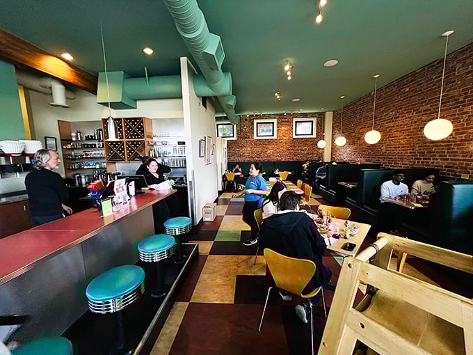 Exposed brick walls, mint-green ceiling, and pendant lights create the kind of cozy atmosphere where breakfast memories are made.