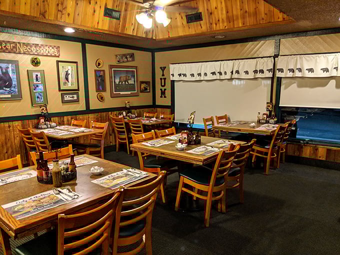 The dining area whispers "stay awhile" with its wood-paneled walls and bear-themed decor—like dining in a cabin your outdoorsy uncle might own.