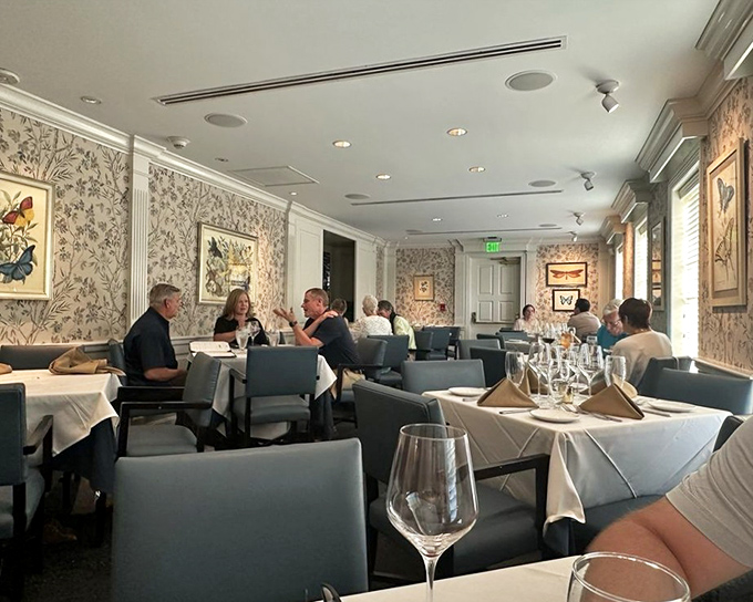 A dining room where elegance doesn't mean stuffiness. The floral wallpaper and soft lighting create the perfect backdrop for both first dates and fiftieth anniversaries.