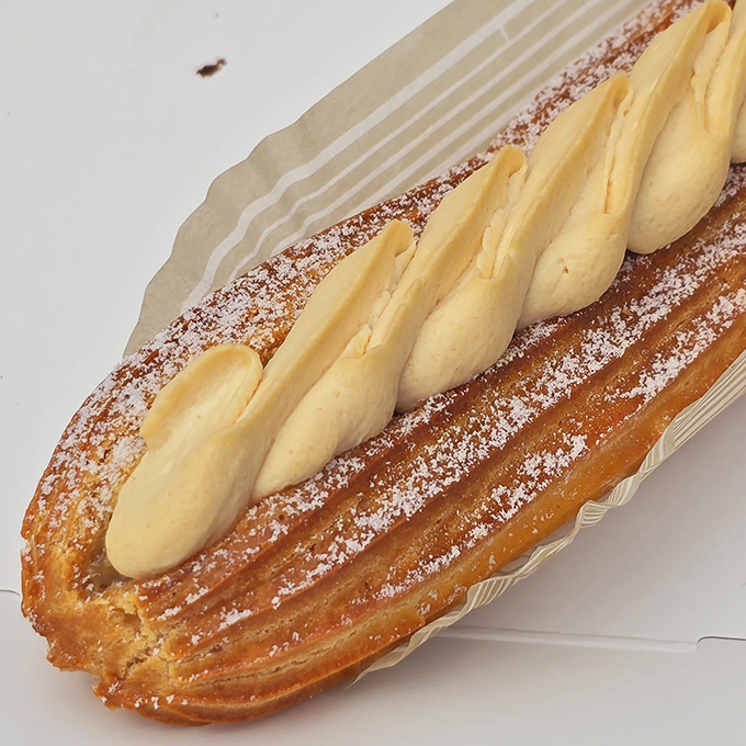 This éclair isn't just dessert—it's a butter-laden magic trick that somehow transforms into a cloud when it hits your tongue.
