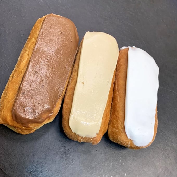 The holy trinity of &eacute;clairs&mdash;chocolate, vanilla, and white&mdash;each one a perfect vessel of creamy filling encased in tender pastry that shatters just right.
