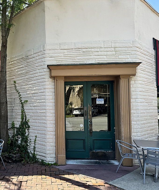The charming entrance with its green doors and white stone exterior feels like stepping into Savannah's storied past, minus the hoop skirts.