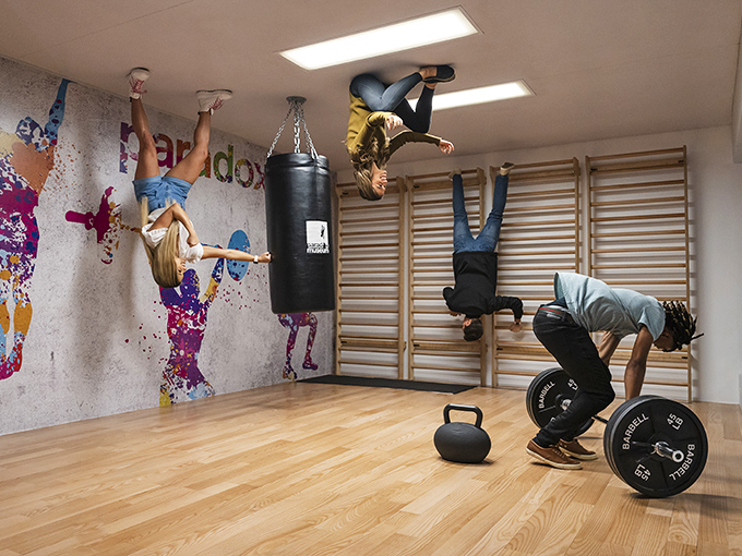 Defying gravity is just another day at the Paradox Museum, where visitors appear to hang from the ceiling in this cleverly designed gym illusion.