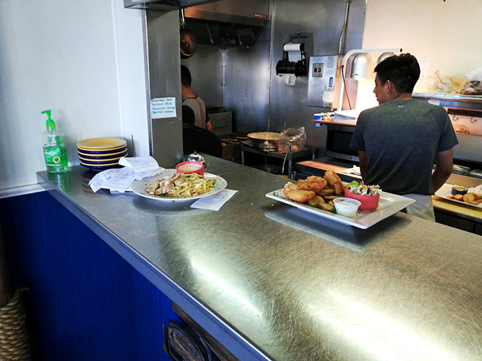 The kitchen counter reveals the beautiful chaos of seafood preparation &ndash; where orders become art and the staff orchestrates your meal with the precision of a maritime ballet.