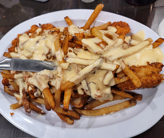 Loaded fries that blur the line between side dish and main event&mdash;a cheese-covered masterpiece that requires both a fork and dedication.
