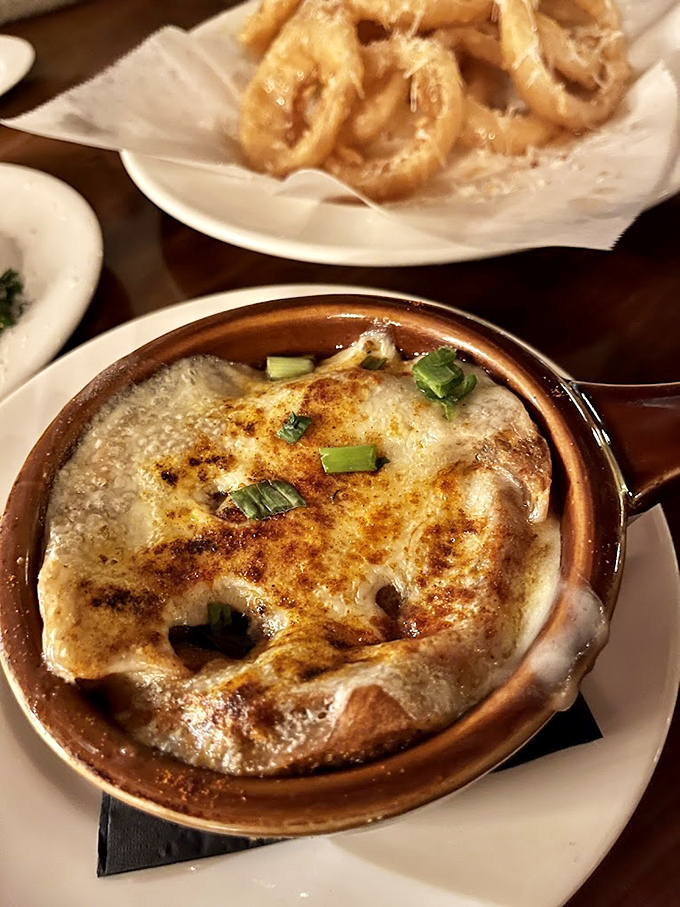 French onion soup that's achieved cult status &ndash; a bubbling cauldron of sweet onions and savory broth beneath a blanket of melted cheese that stretches with each spoonful.