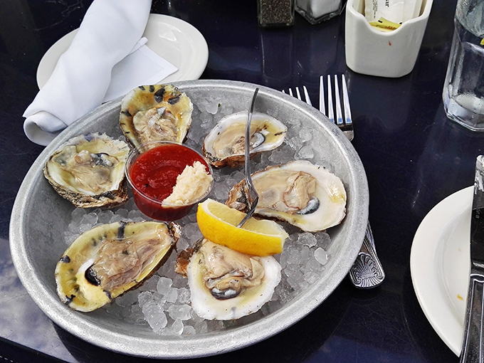 Fresh oysters lounging on ice like celebrities at a beach resort. That tiny fork is the VIP pass to briny perfection.