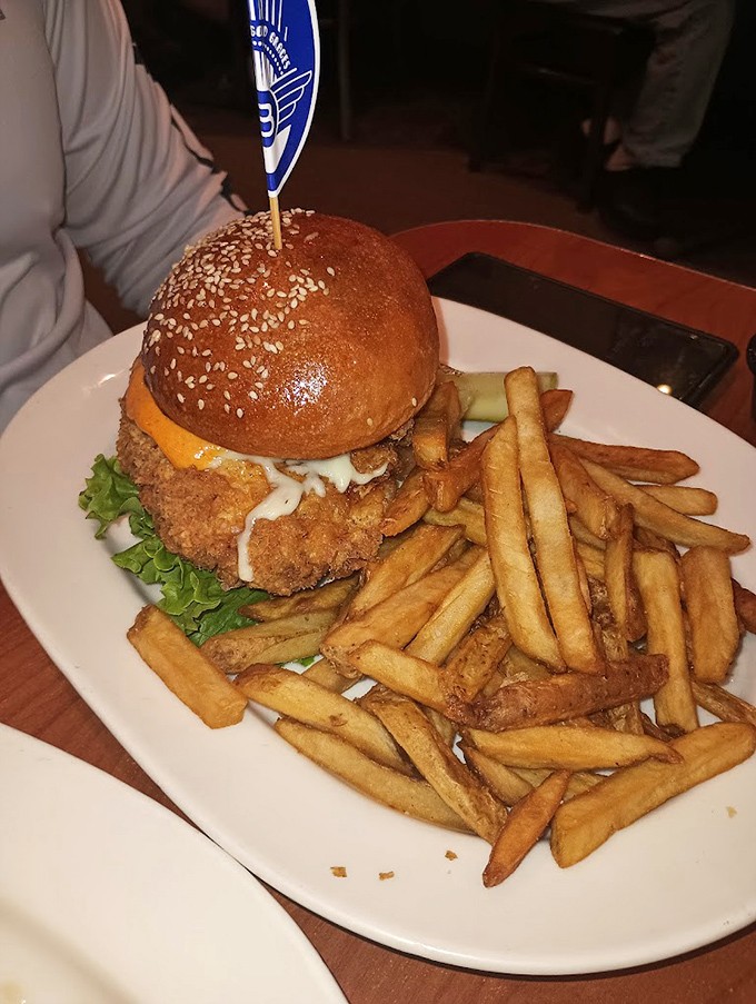 This isn't just a chicken sandwich&mdash;it's a masterclass in texture. That golden-brown exterior practically sings when you cut into it. Fries looking mighty fine too.