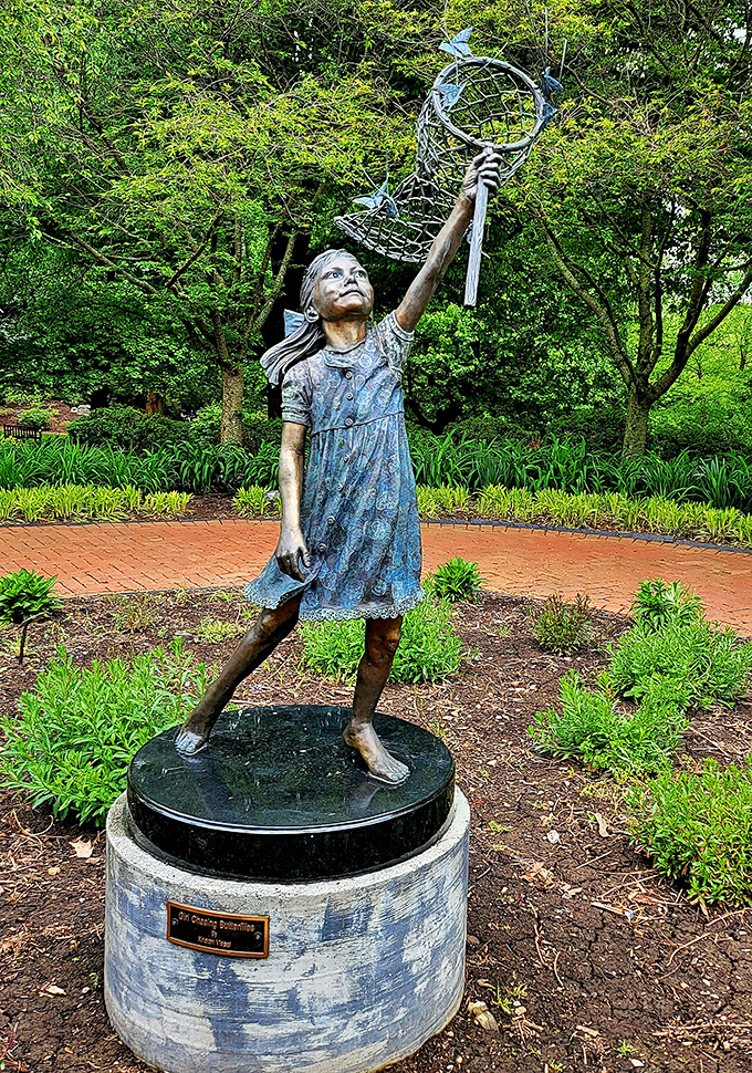 This bronze girl reaching for butterflies captures that universal childhood moment when we all believed we could catch magic with our bare hands.