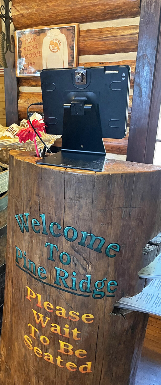 A host stand carved from a single tree trunk welcomes you with Northwoods charm and the promise of being seated soon.