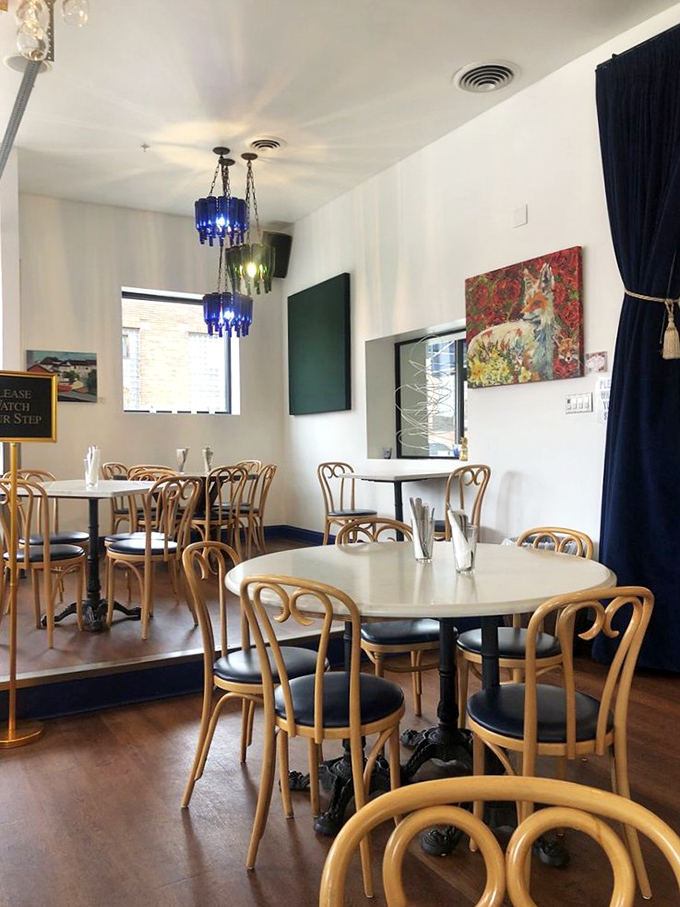The dining room balances elegance and comfort, where blue bottle chandeliers cast their spell over conversations and first dates alike.