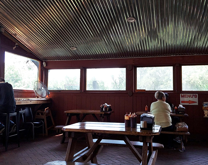 The corrugated ceiling reflects more than light&mdash;it bounces back decades of BBQ tradition. Windows frame Florida greenery while picnic tables invite lingering conversations.
