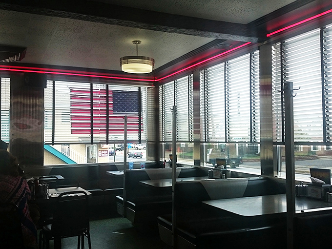 Red neon trim casts a warm glow over diners enjoying that perfect balance of privacy and community only found in classic booths.