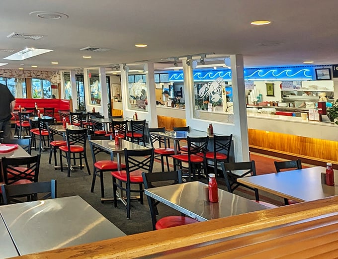 Red chairs pop against metal tables in this seafood sanctuary. No pretension here—just the promise of ocean treasures to come.