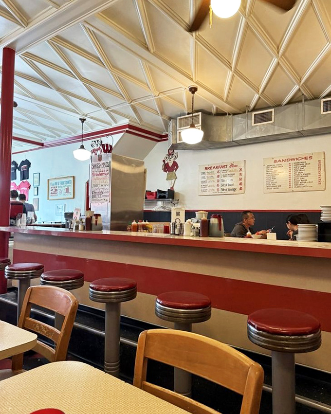 Red stools lined up at the counter like patient sentinels, waiting for the next generation of Badger fans to create memories.