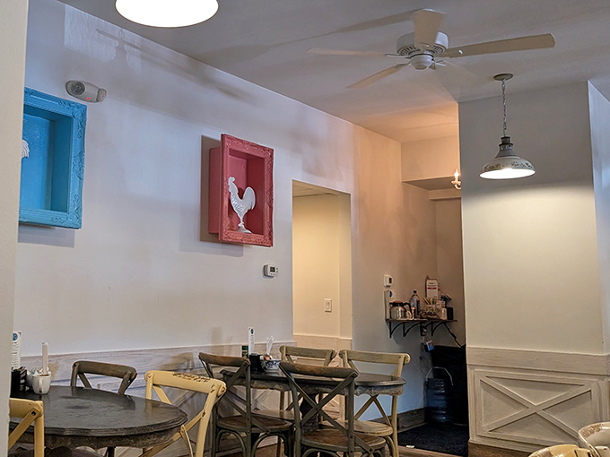 Whimsical rooster art watches over diners like breakfast guardians. The pendant lighting sets a mood that says "casual elegance with a side of syrup."