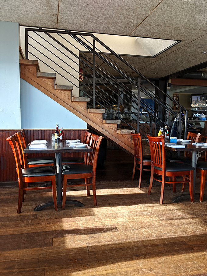The staircase divides the dining space like the prow of a ship, while wooden chairs invite you to settle in for a seafood journey.