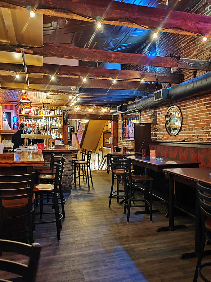 Exposed brick, wooden beams, and the soft glow of string lights create the perfect backdrop for stories that get better with each round.