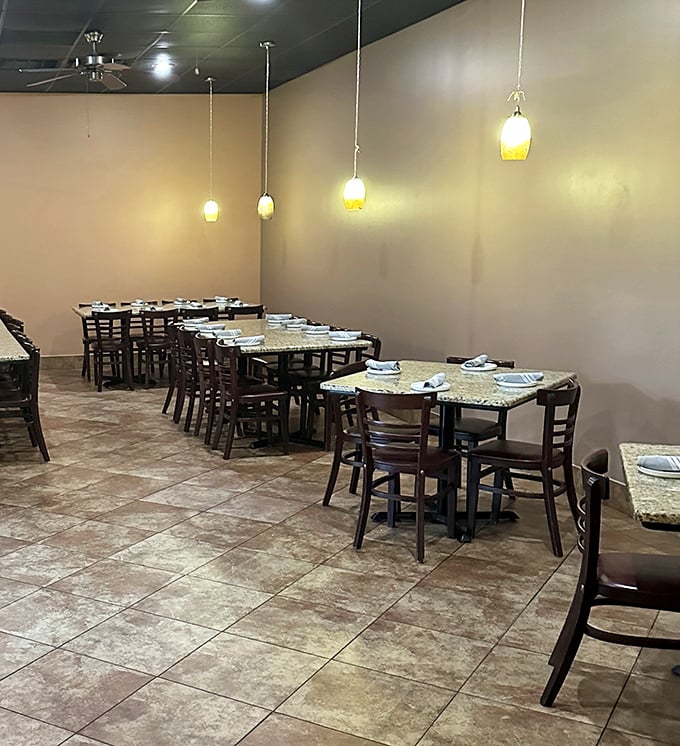 Soft pendant lighting casts a warm glow over granite-topped tables. The dining room feels like that perfect dinner party where everyone's invited and the food's always amazing.