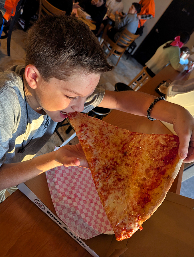 The universal language of pizza joy &ndash; when that first bite creates a moment of pure childhood bliss regardless of your actual age.