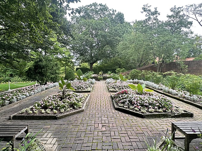 Geometric precision meets floral abundance in this garden section where brick pathways guide visitors through a living tapestry of colors and textures.